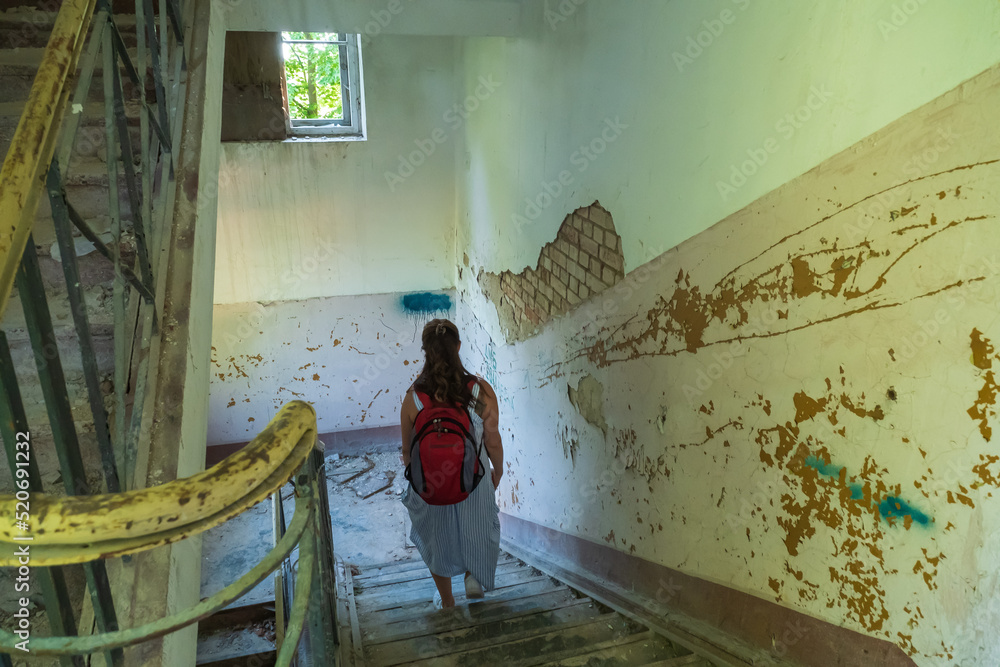 Female walking on steps inside desolate building Stock Photo | Adobe Stock