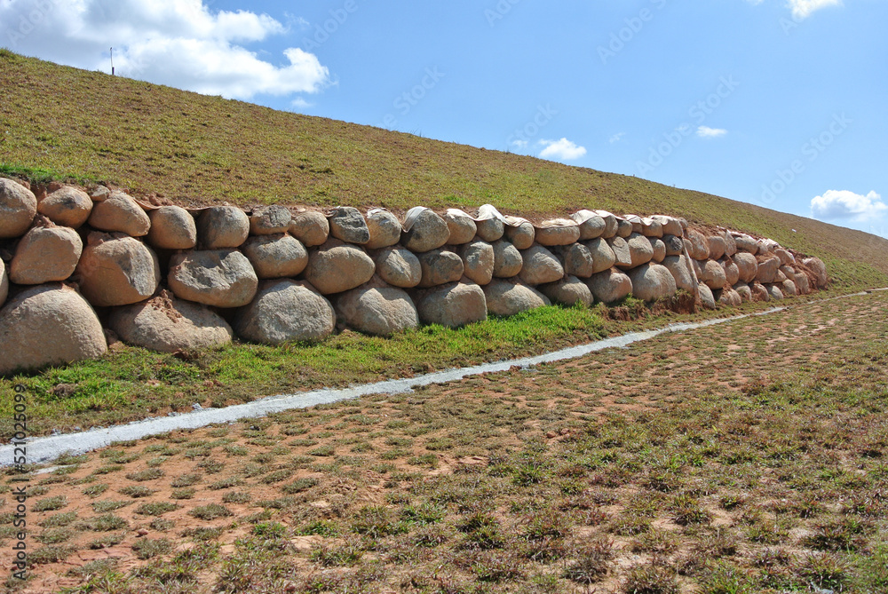 Natural boulders are used as retaining walls of ground banks that have ...