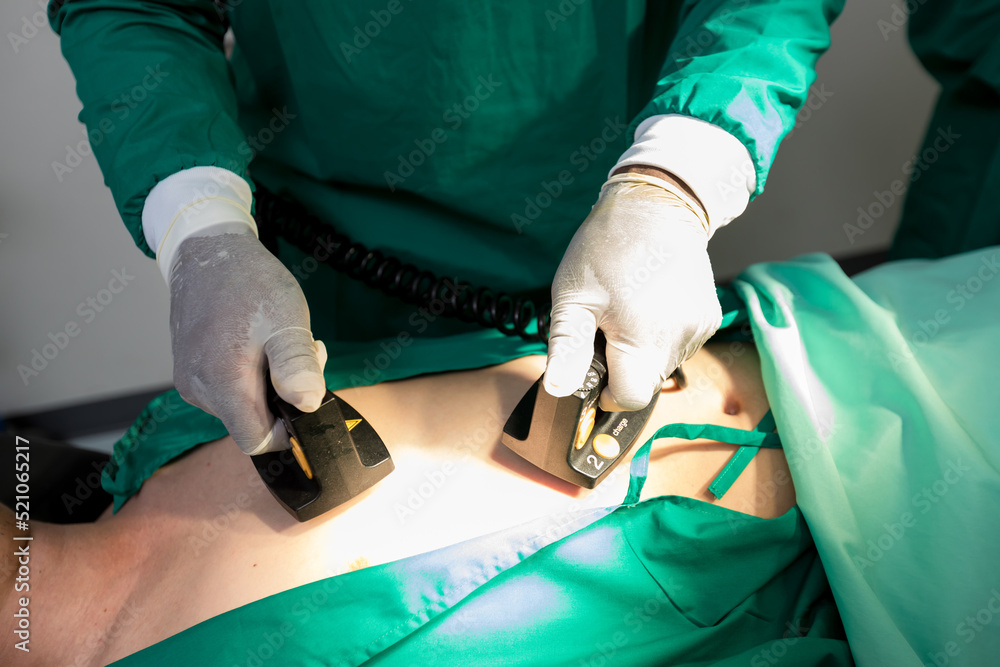 The doctor is giving a defibrillators to save the patient's life in the ...