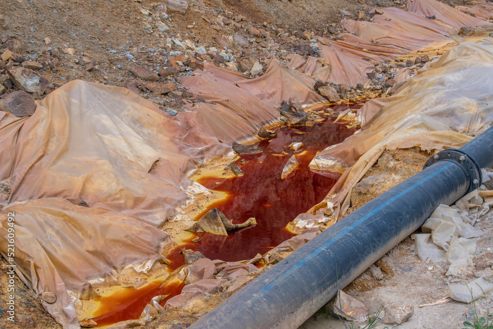 Red polluted toxic water in copper mine. Mining of ores of various ...