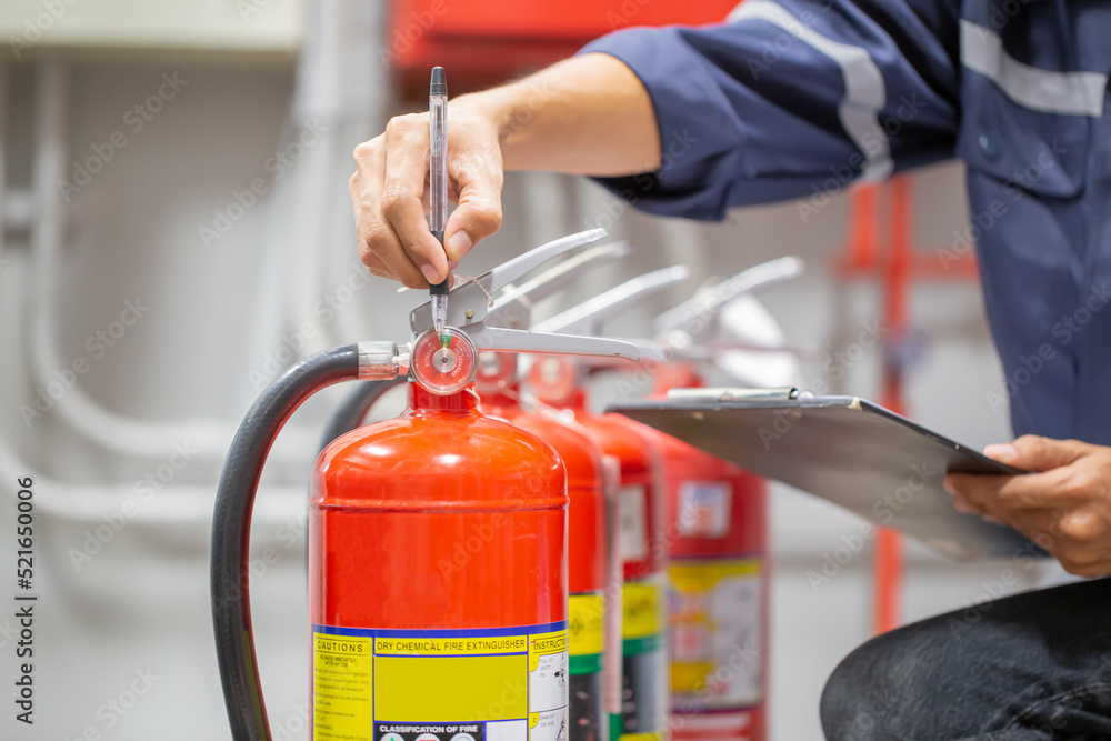 Engineer are checking and inspection a fire extinguishers tank in the fire control room for ...