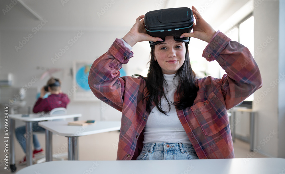 Happy student wearing virtual reality goggles at school in computer ...