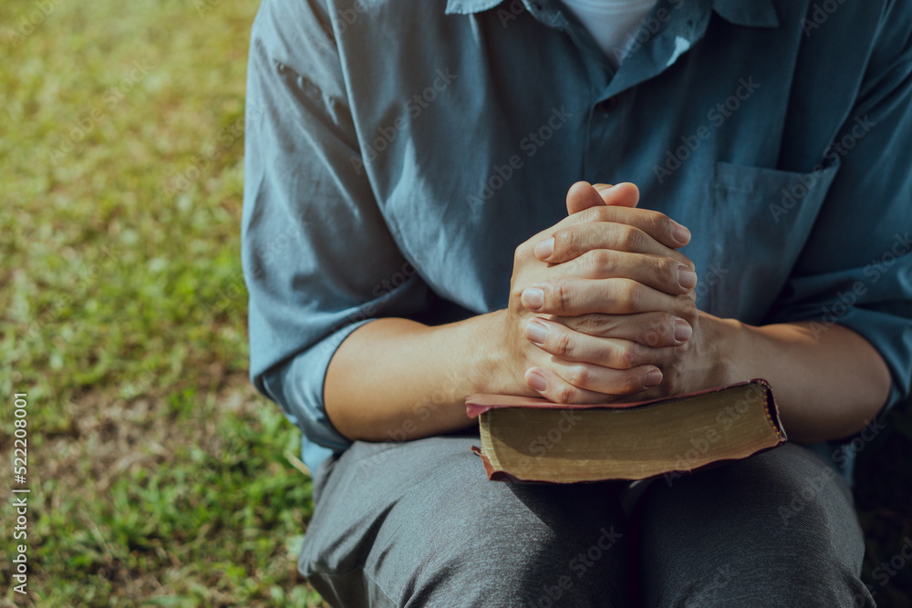 Young prayer sitting outdoor for reading bible and worship god, garden ...
