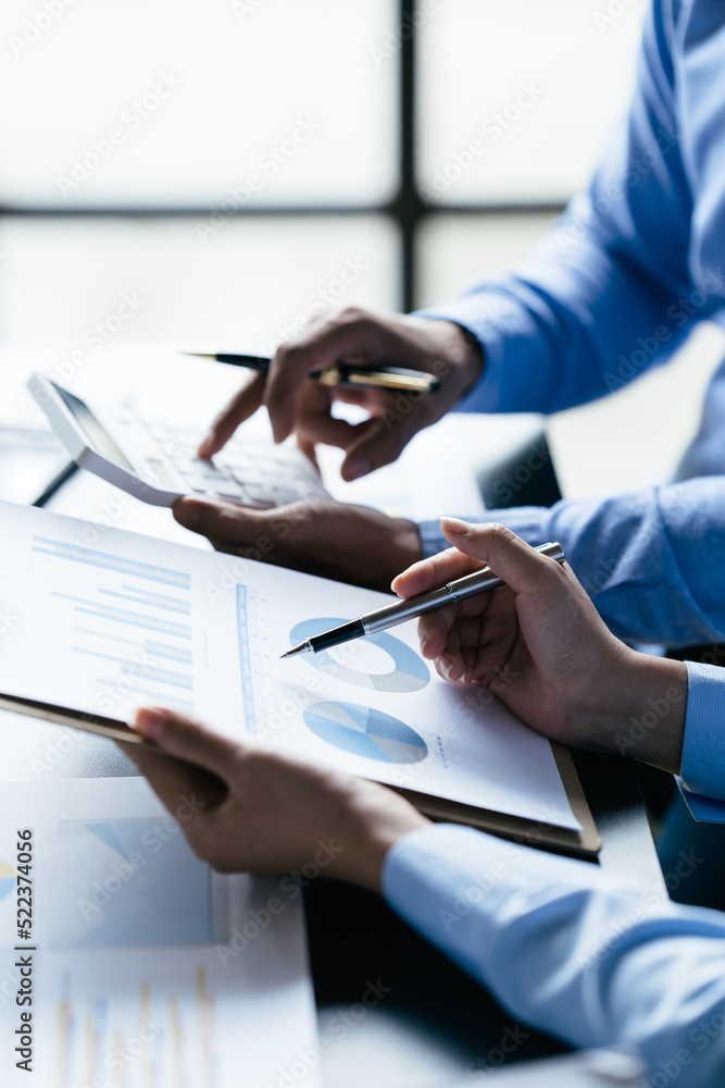 Business team reviewing a diagram or chart and financial reports for a return on investment or ...