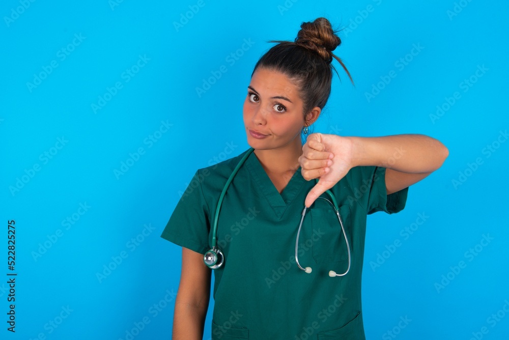 beautiful doctor woman wearing medical uniform over blue background ...