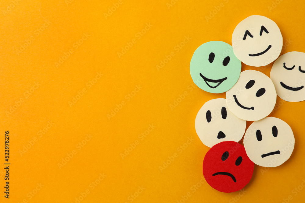 Many faces with different emotions on yellow background, flat lay ...