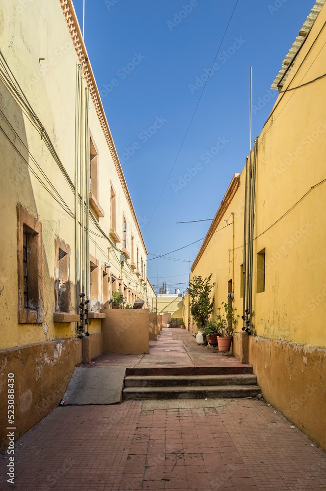 central courtyard of a neighborhood, yellow houses with brick, stairs ...