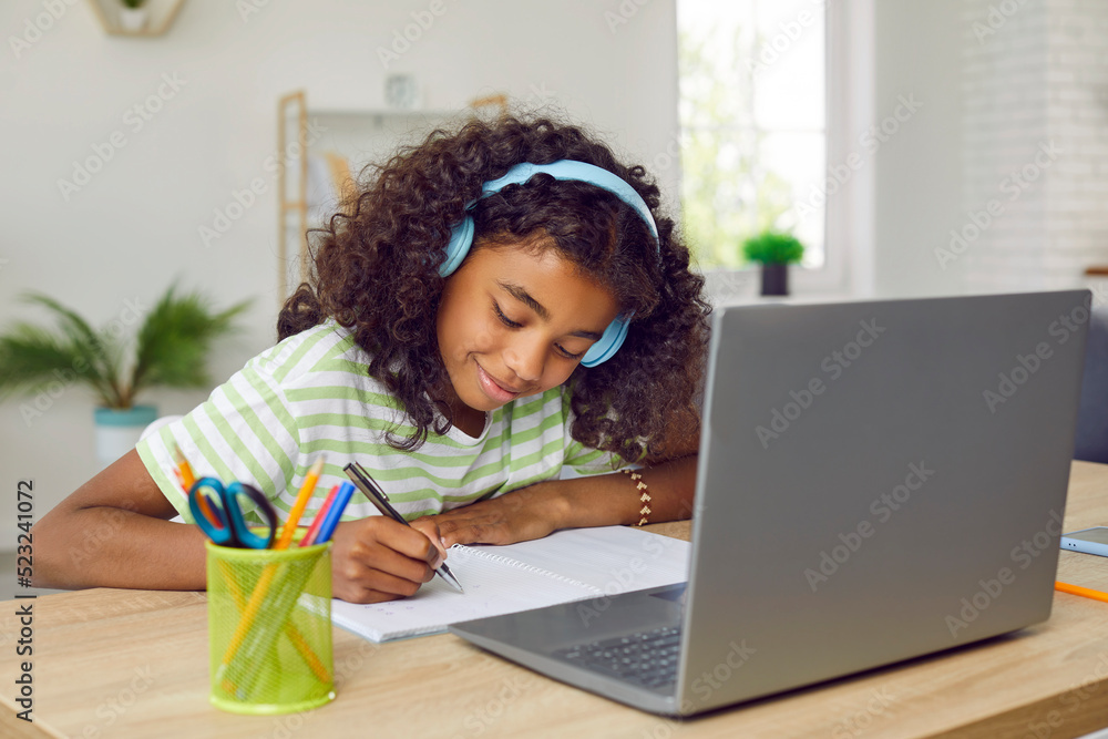 Happy elementary school child studying online. African American student ...