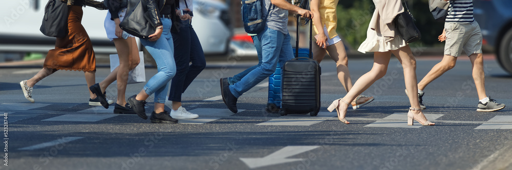 A crowd of pedestrians crossing street in the city, people walking in ...