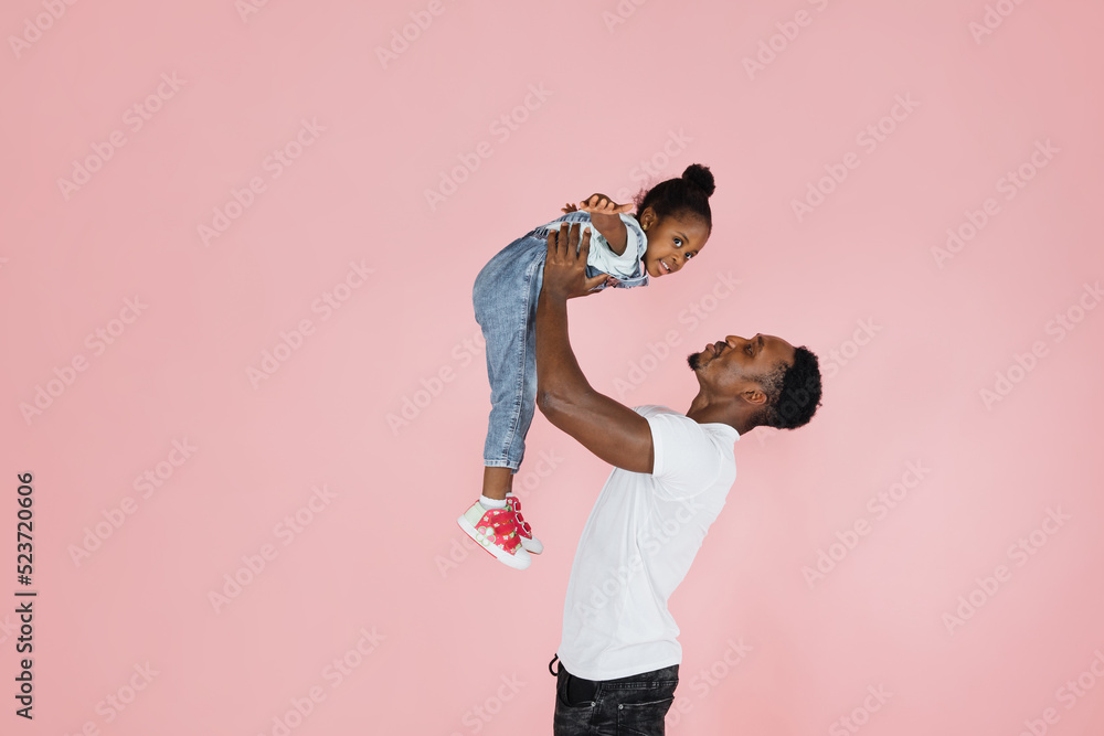Happy fatherhood. Cheerful african dad holding his cute daughter on ...