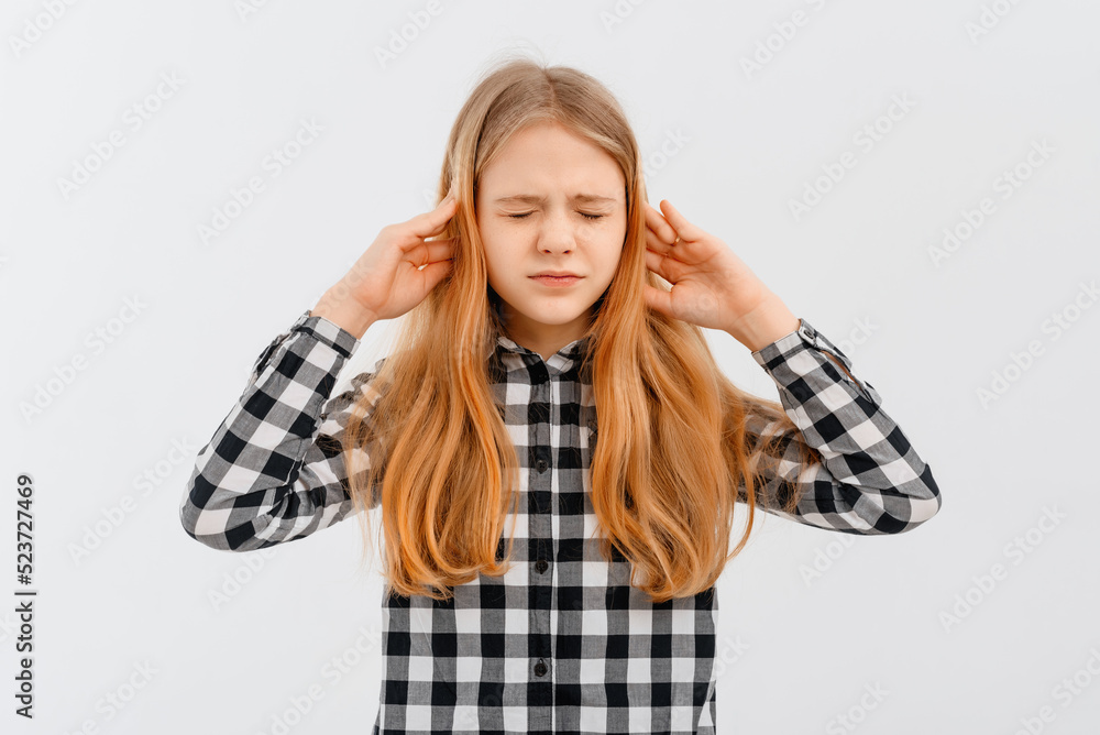 Angry teen girl covering ears with hands. Girl plugs her ears with her ...
