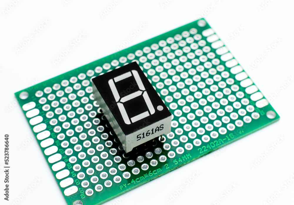 Seven segment indicator attached to a green printed circuit board on a white background ...