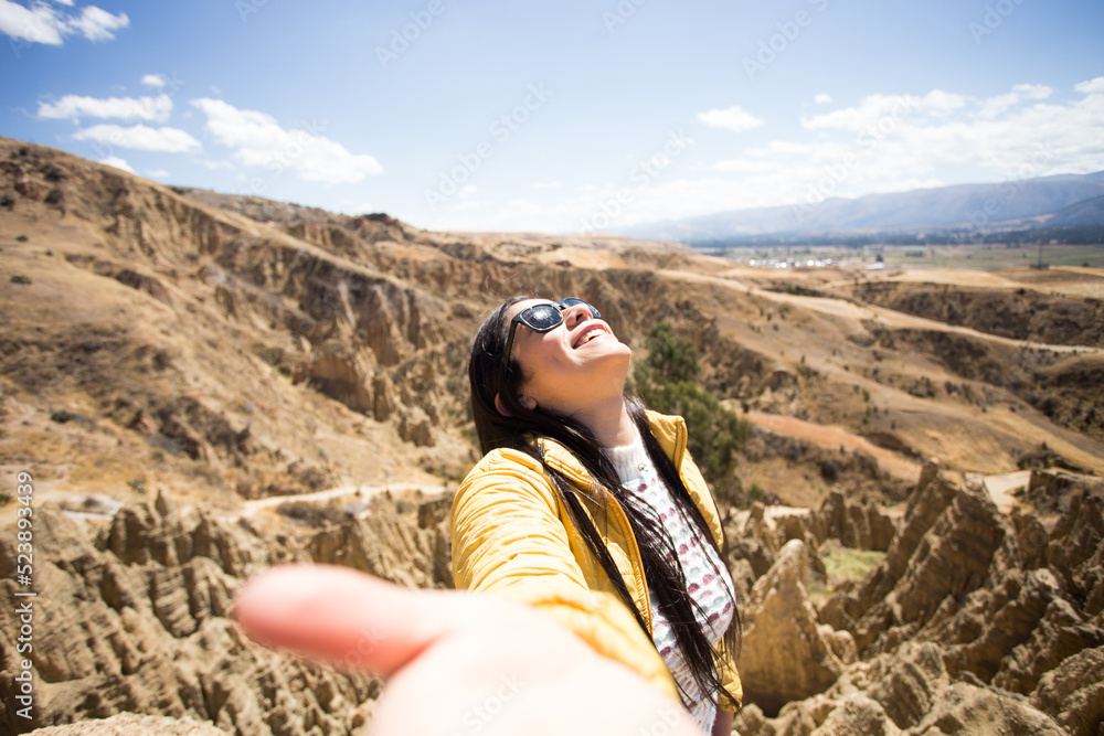 Mujer turista sonriendo tomándose un selfie en lo alto de una montaña ...