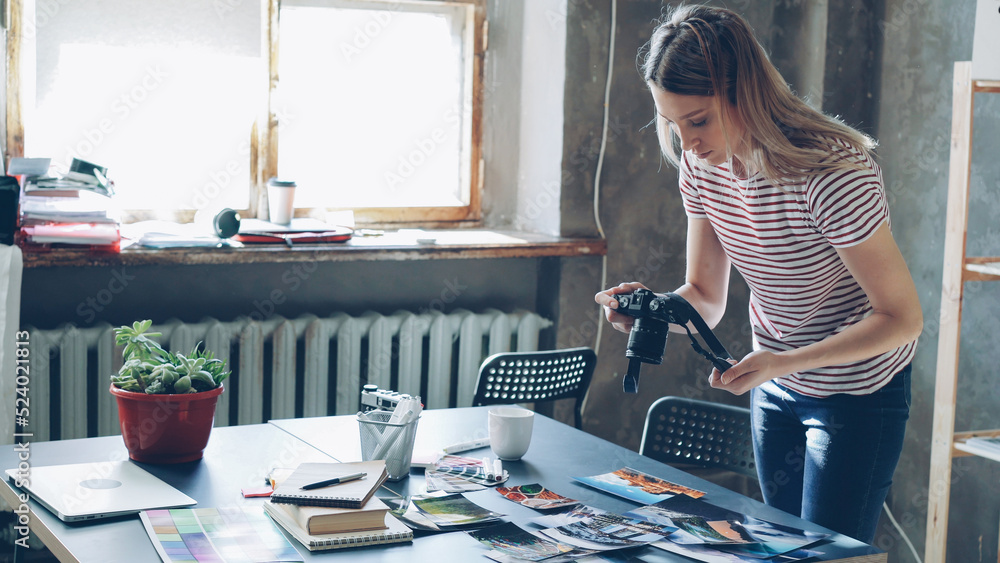 Young attractive female blogger using digital camera to shoot colourful ...