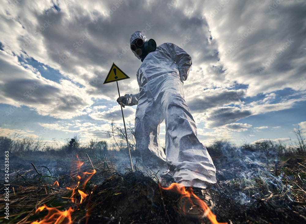 Fireman ecologist fighting fire in field. Man in protective radiation ...