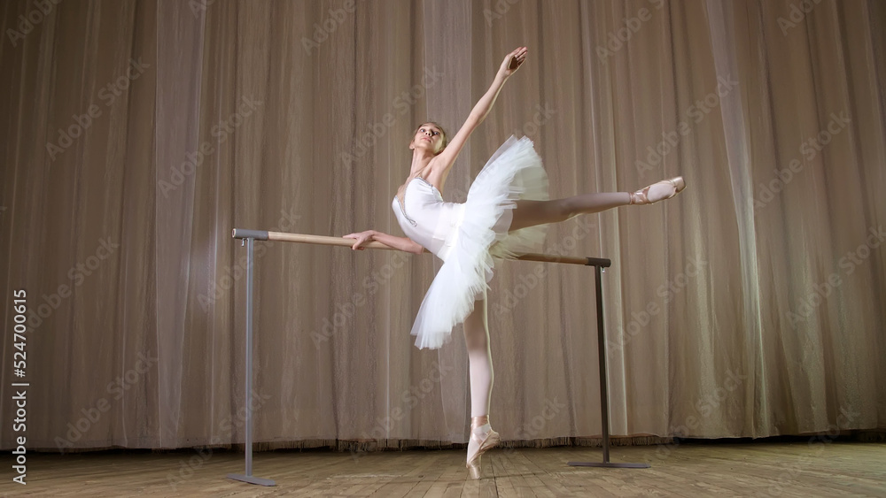 ballet rehearsal, in old theater hall. Young ballerina in white ballet ...