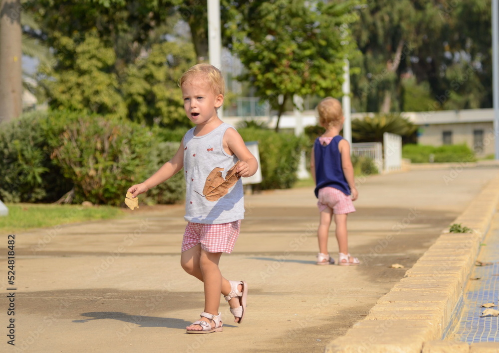 Twin girls. Sisters two years old. Cute positive kids play in the park ...