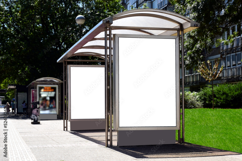 bus shelter with blank white ad panel and light box. urban setting with ...