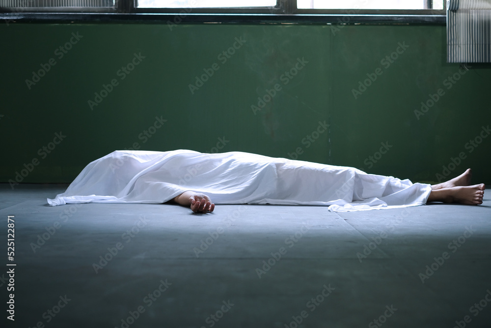 Dead woman lying down under white cloth covered death body from murder ...