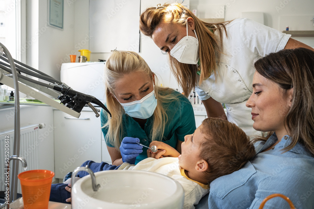 Little boy doing a teeth examination by a professional specialist in a ...