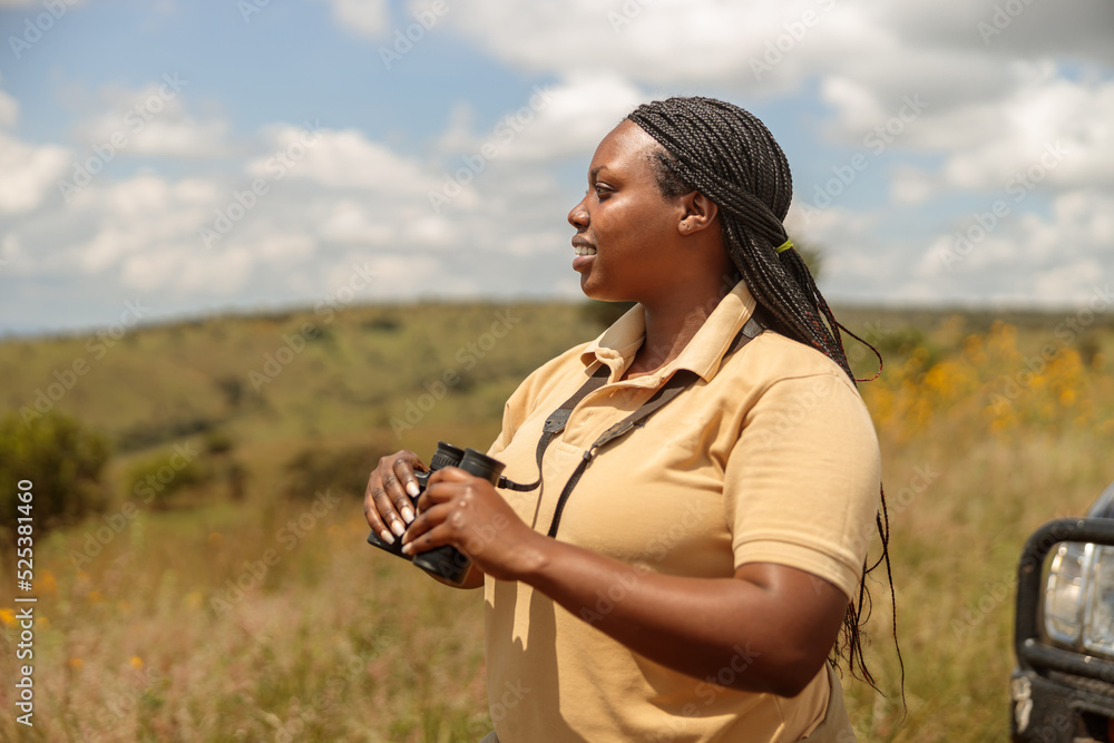 Side view of emale tour guide using binoculars and searching the ...