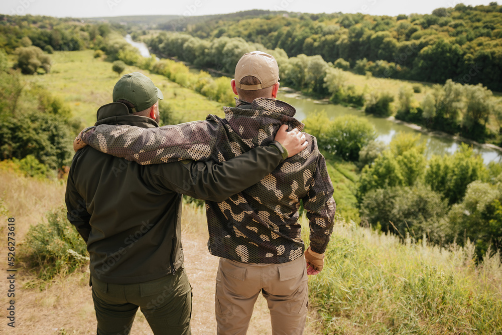 Two guys hunters fishers wearing tactical hunter gear happy meet each ...