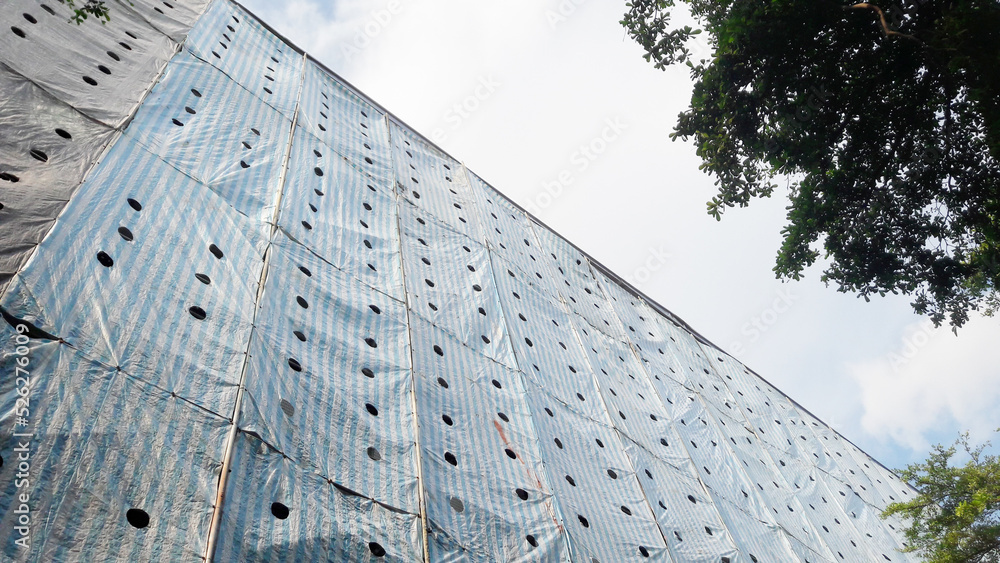 High-rise buildings under construction that use a protective canvas ...