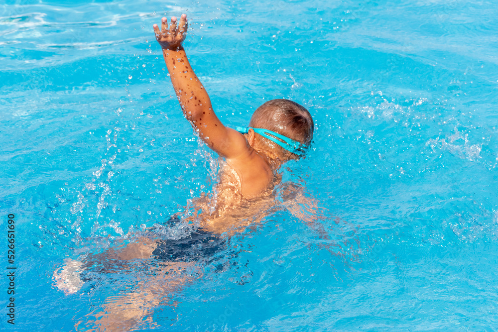 Little boy beginner swimmer learn to swim in pool crawl. Kid swimming ...