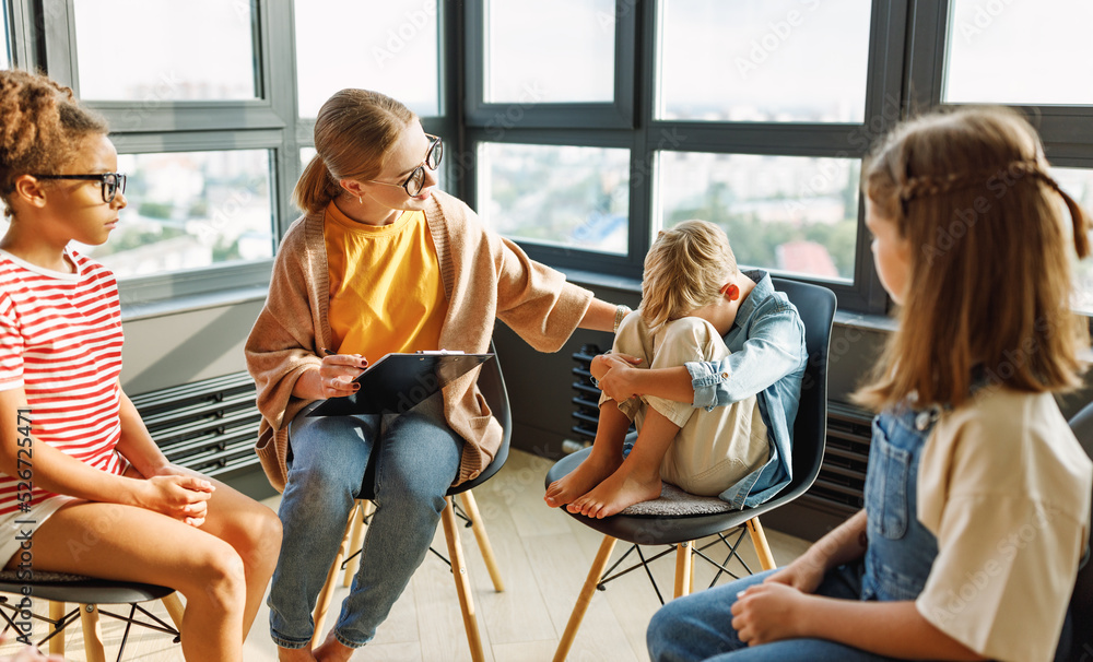 School psychologist with a group of children conducts a mental health ...