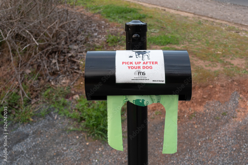 Dog poo waste green bag black holder dispenser in the park Australia ...
