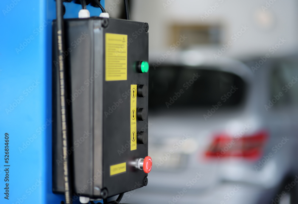 Control panel of the car lift in the garage of the car service. An ...