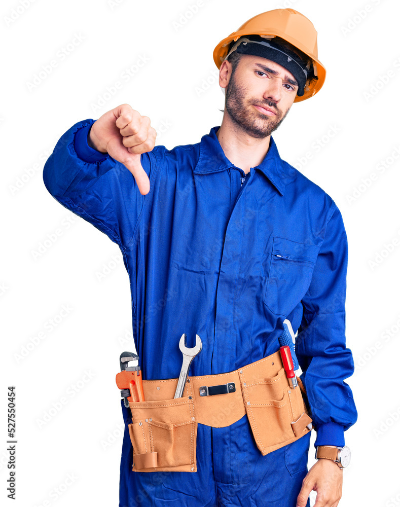 Young hispanic man wearing worker uniform looking unhappy and angry ...