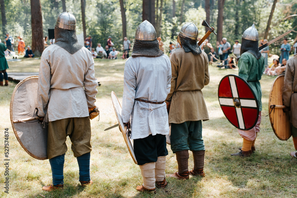 Vikings in helmets with weapons standing on the battlefield outdoors ...