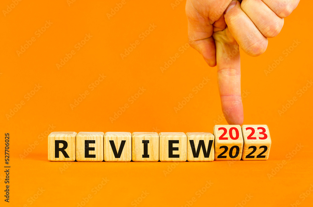 2023 review new year symbol. Businessman turns a wooden cube and ...
