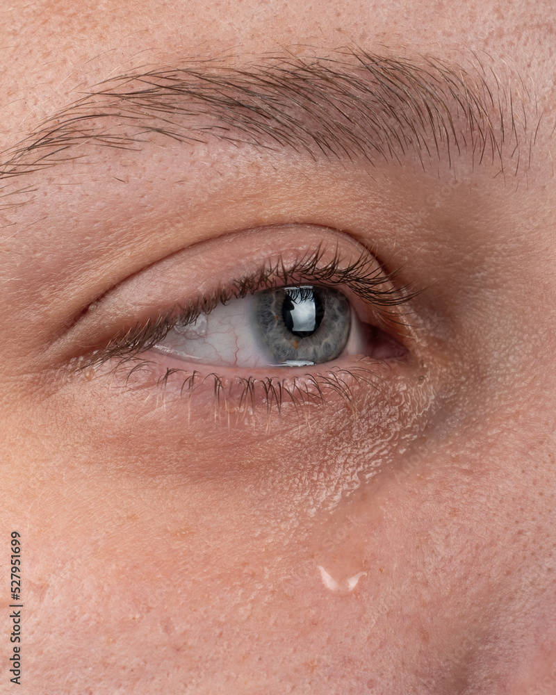 eye with a tear flowing down a woman cheek Stock Photo | Adobe Stock