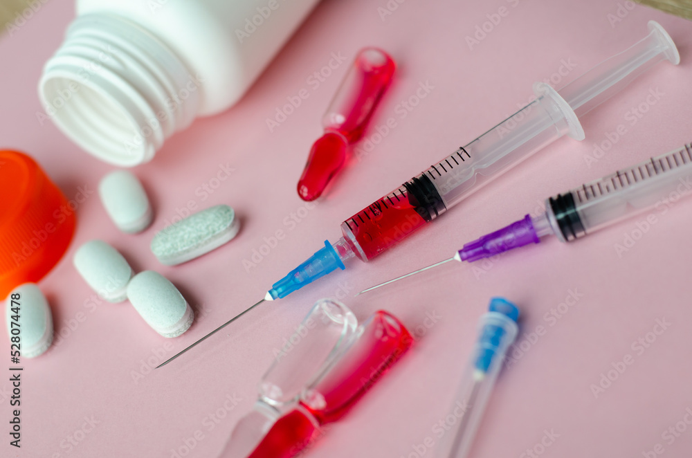 Vaccination. Syringe with medicinal substance. Tablets and capsules on ...