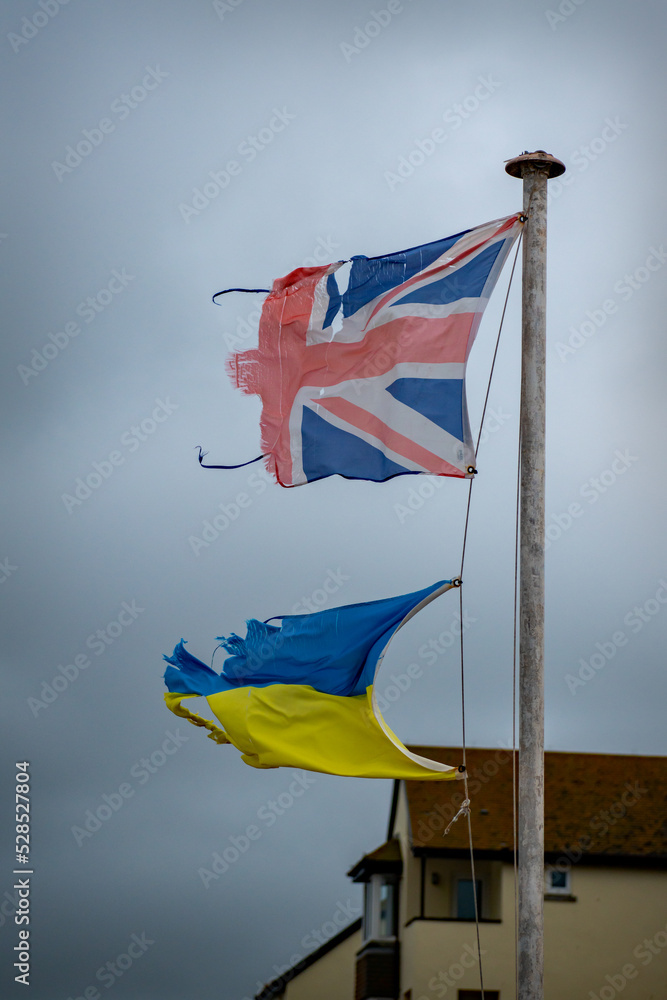 Foto Ripped and tatty Union jack flag and Ukrainian flag fly together ...