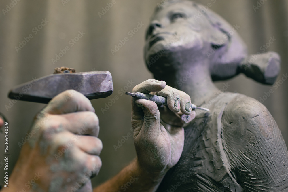 Man sculptor creates sculpt bust human woman sculpture with hammer ...