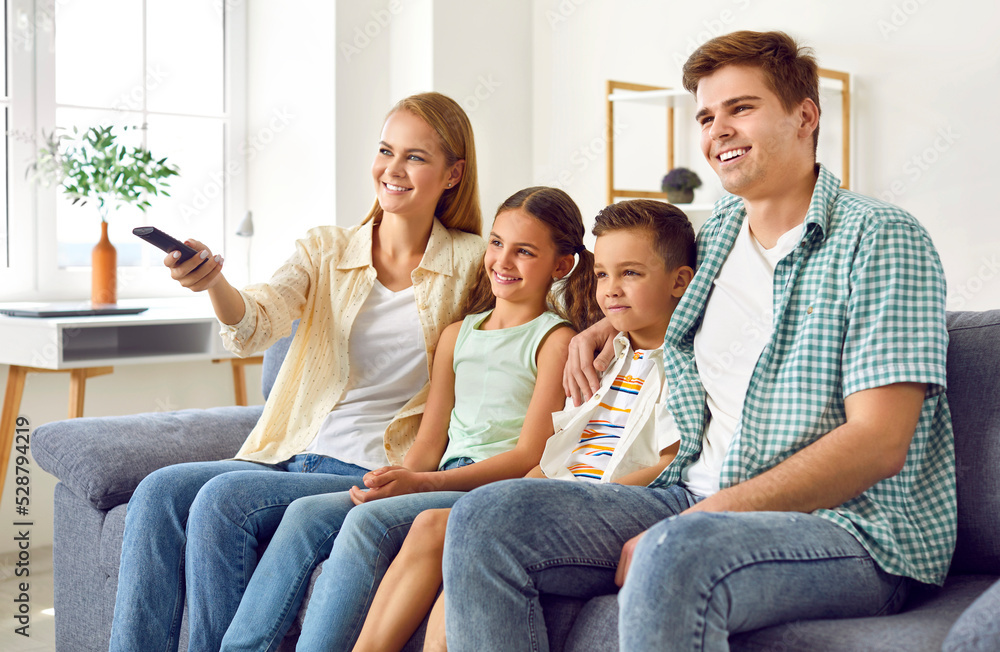 Stock-Foto „Happy parents and kids watching TV together. Beautiful ...