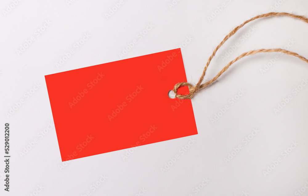Red rectangular empty price tag with place to insert text on a string ...