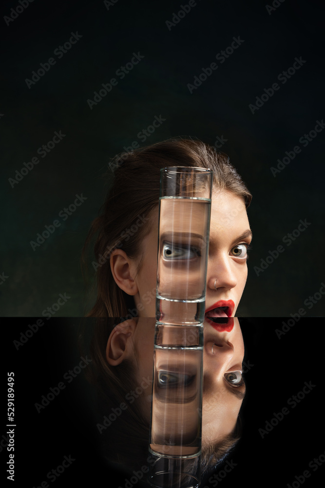 Creative art photography. Young girl's face through glass of water over ...