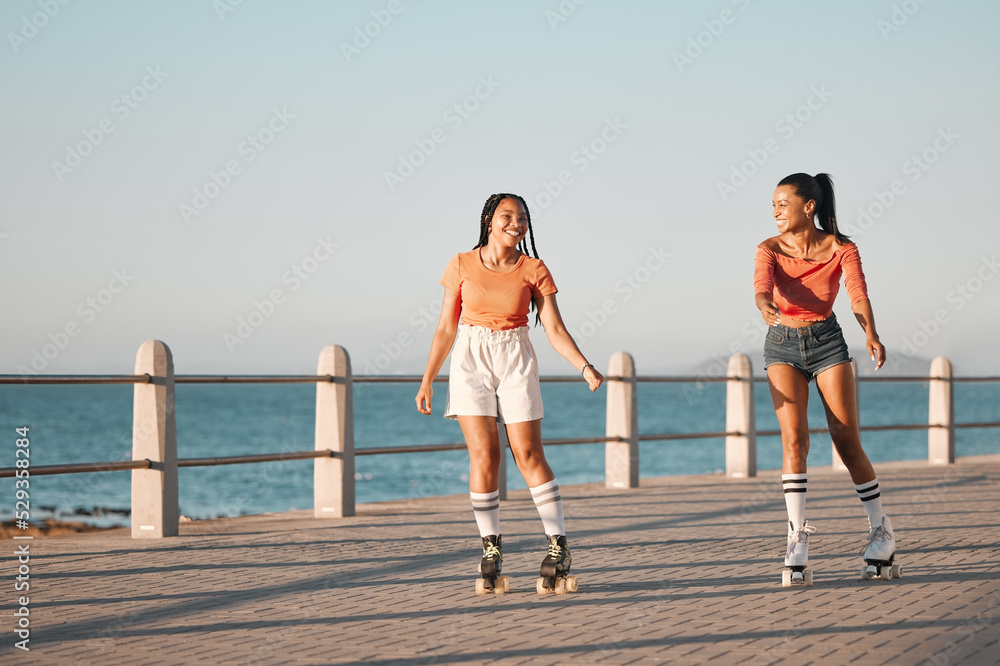 Friends roller skating on the promenade at the beach during a summer ...