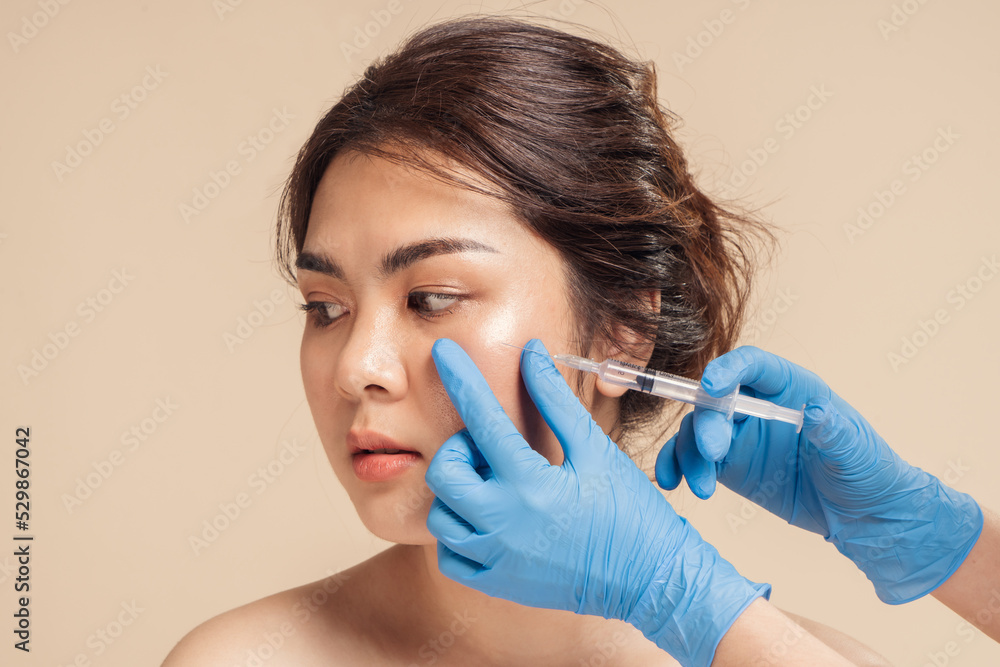 Closeup face young asian woman is getting filler under her eye for anti ...
