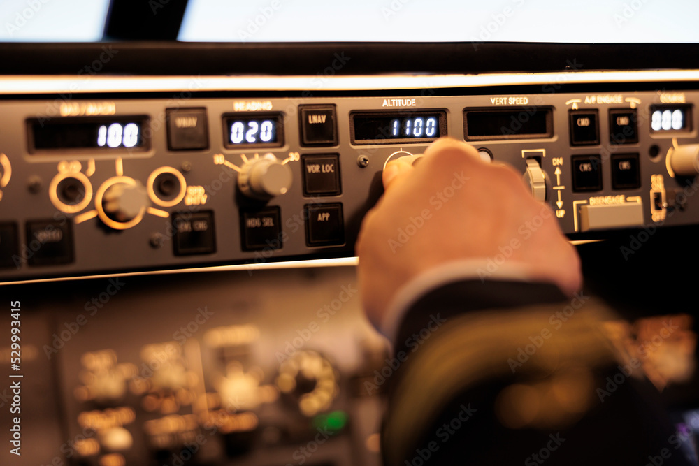 Captain pushing buttons to fix altitude level on control panel command ...
