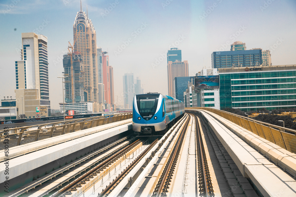 Dubai, UAE. Tube, metro railway track view with City buildings and ...