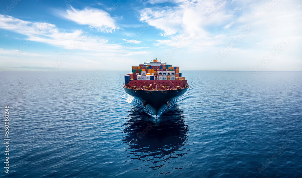 Front view of a big container cargo ship travelling over the ocean with ...