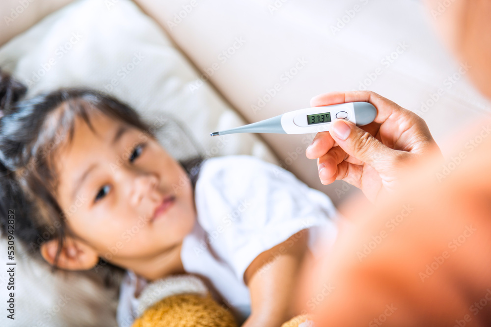 Sick kid. Mother checking temperature of her sick daughter with thermometer in mouth, child ...