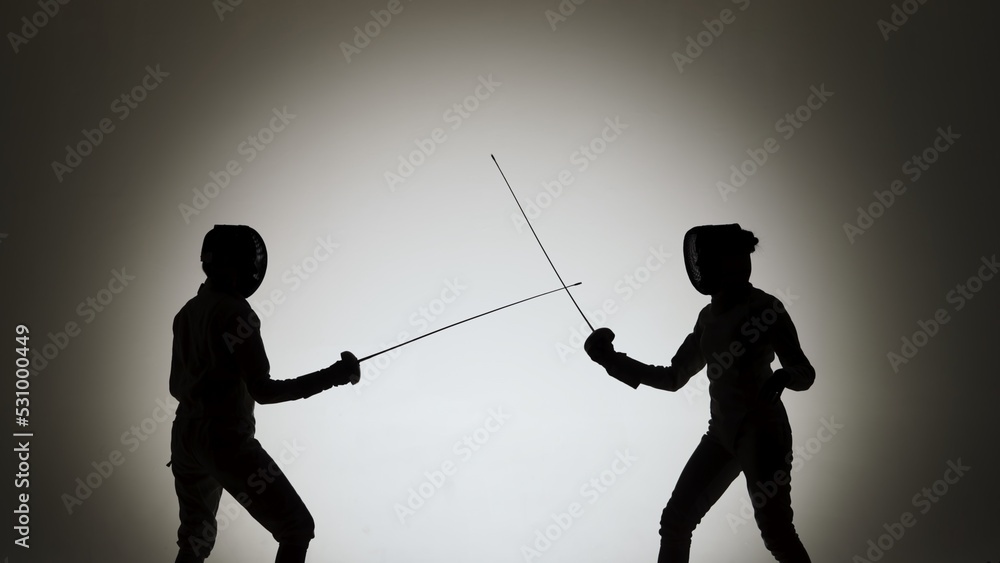 Side view of black silhouettes two young female swordswoman with ...