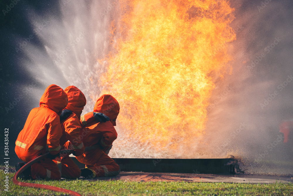 Firefighter fighting with fire flame protection property. Fireman wear ...