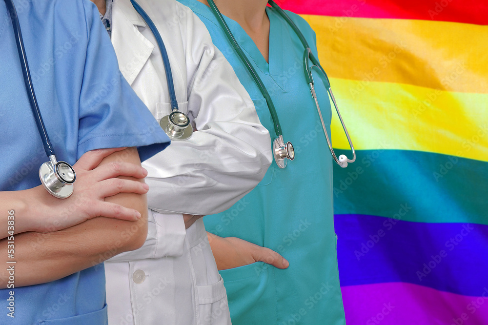 Three Doctors with stethoscope in standing on LGBT flag background ...